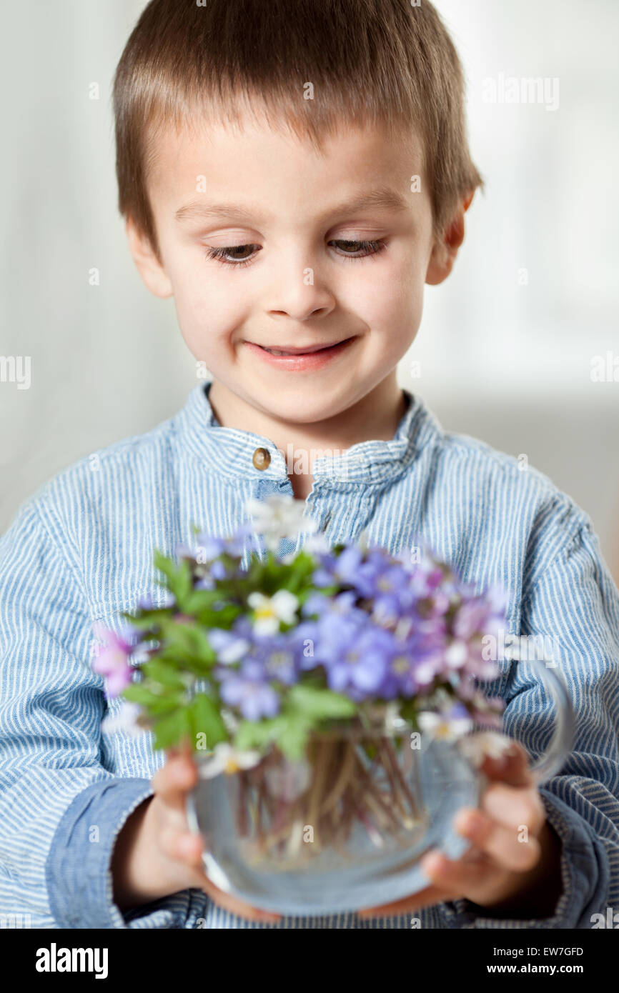 Little hands, holding glass vase with forest spring flower bouquet ...