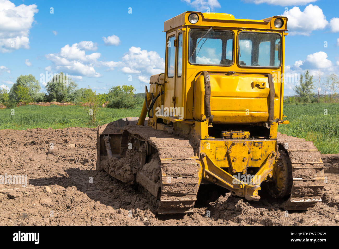 Single earth moving digger covered in mud with cloudy sky Stock Photo ...