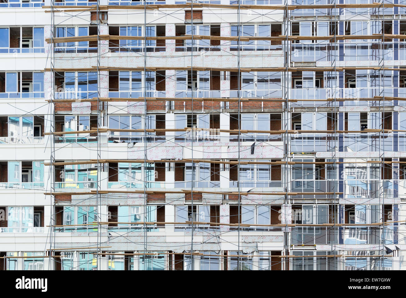 Under construciton building with symmetrical windows and scaffolding ...