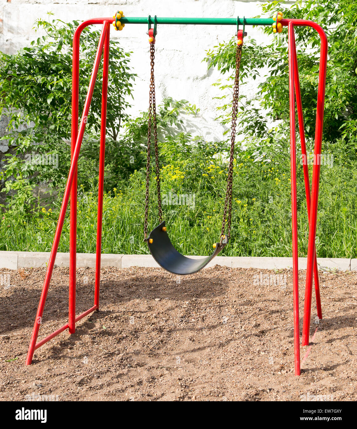 Brightly painted modern kid's red playground swing Stock Photo - Alamy
