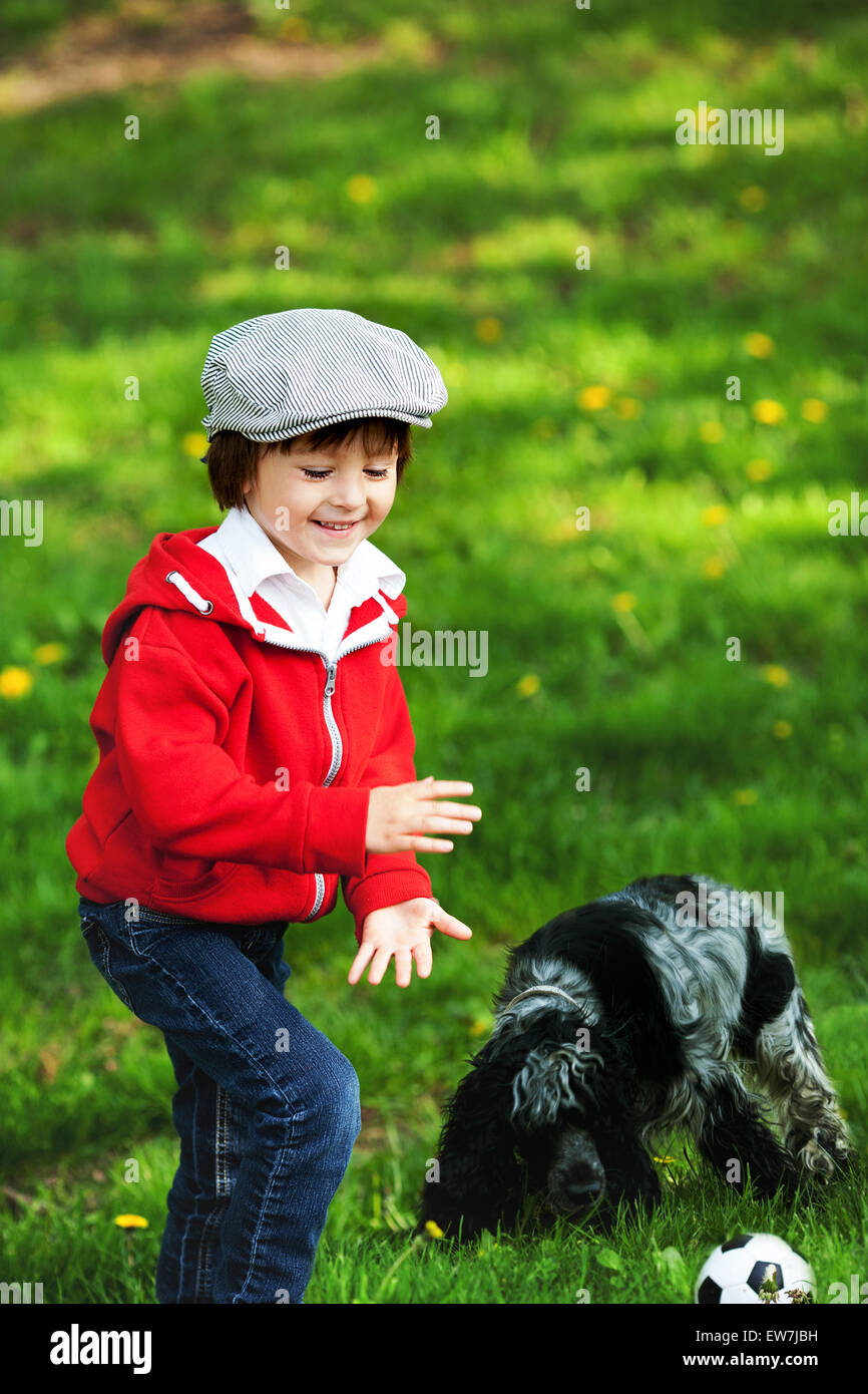 Cute laughing boy and his dog, playing in the park, springtime, daytime ...