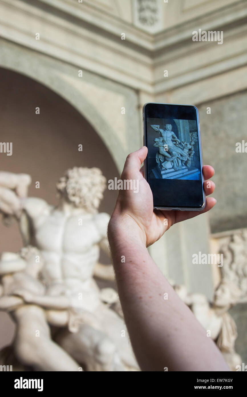 A tourist is taking a picture of the Sculpture of the Laocoön group ...