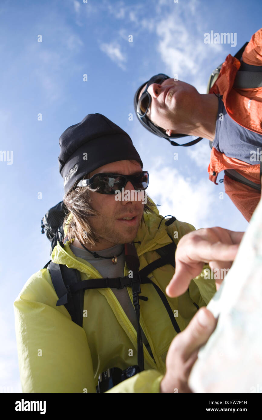 Two backpackers look over a map Stock Photo - Alamy
