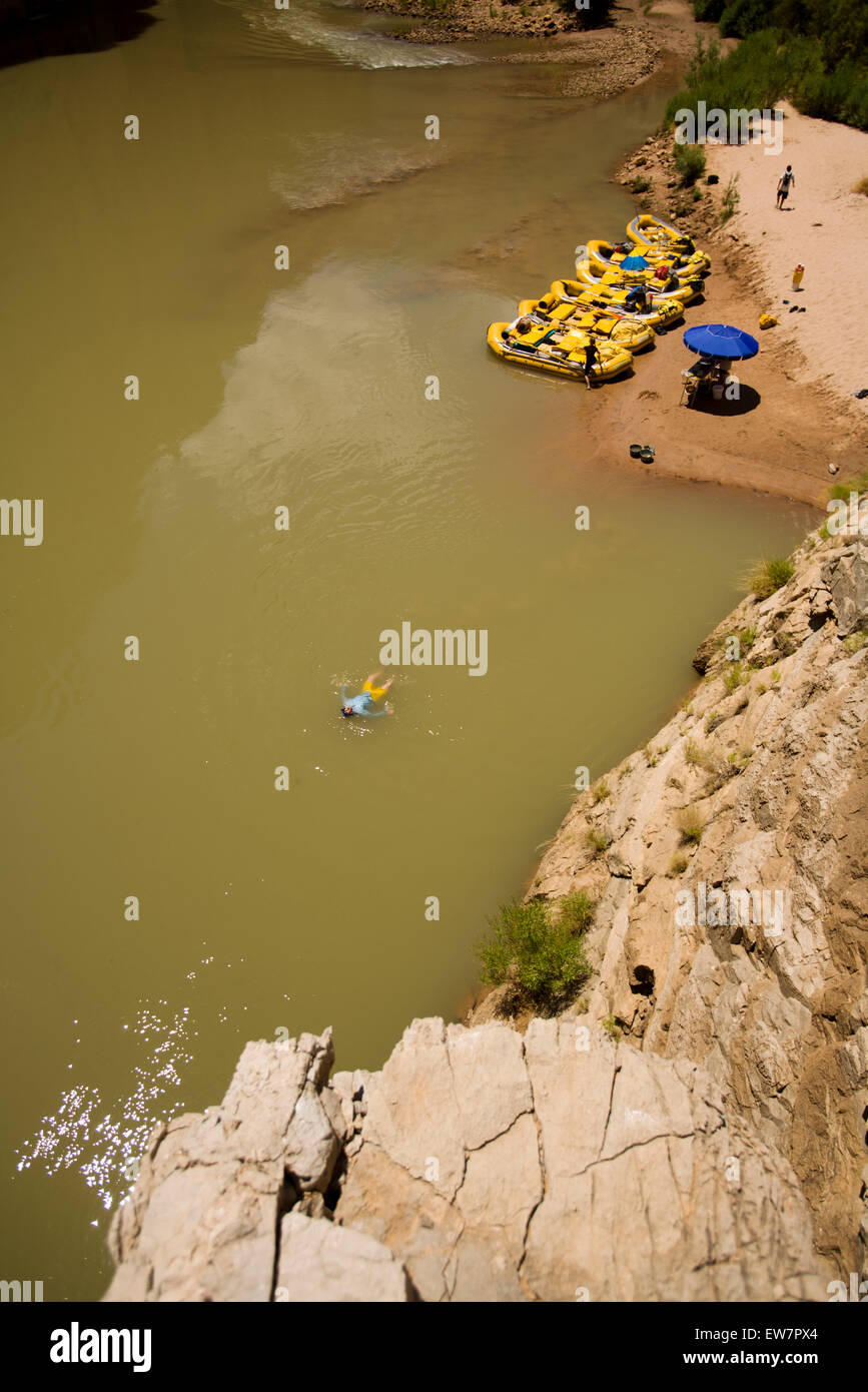 High angle perspective of a man swimming next to rafts on the shore of ...