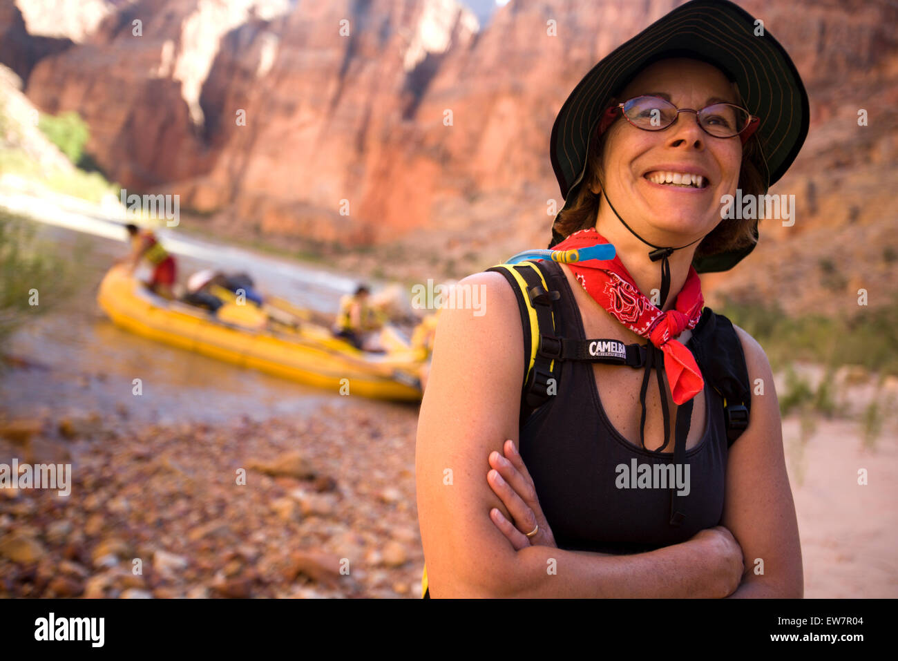 Portrait of a woman by a river and raft deep in a canyon Stock Photo ...