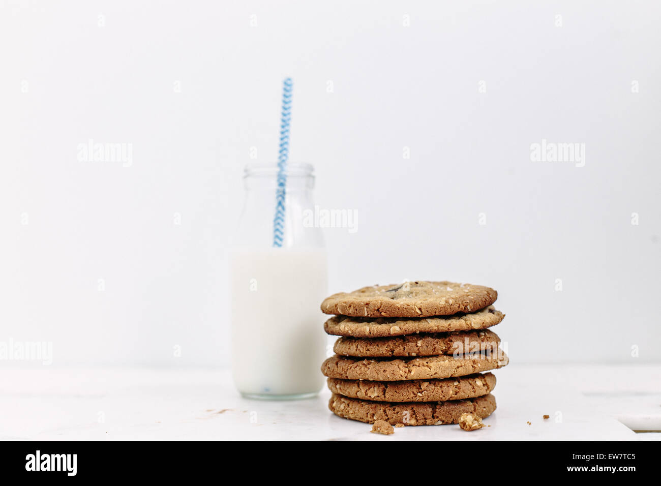 Stack of cookies and bottle of milk with a straw Stock Photo - Alamy