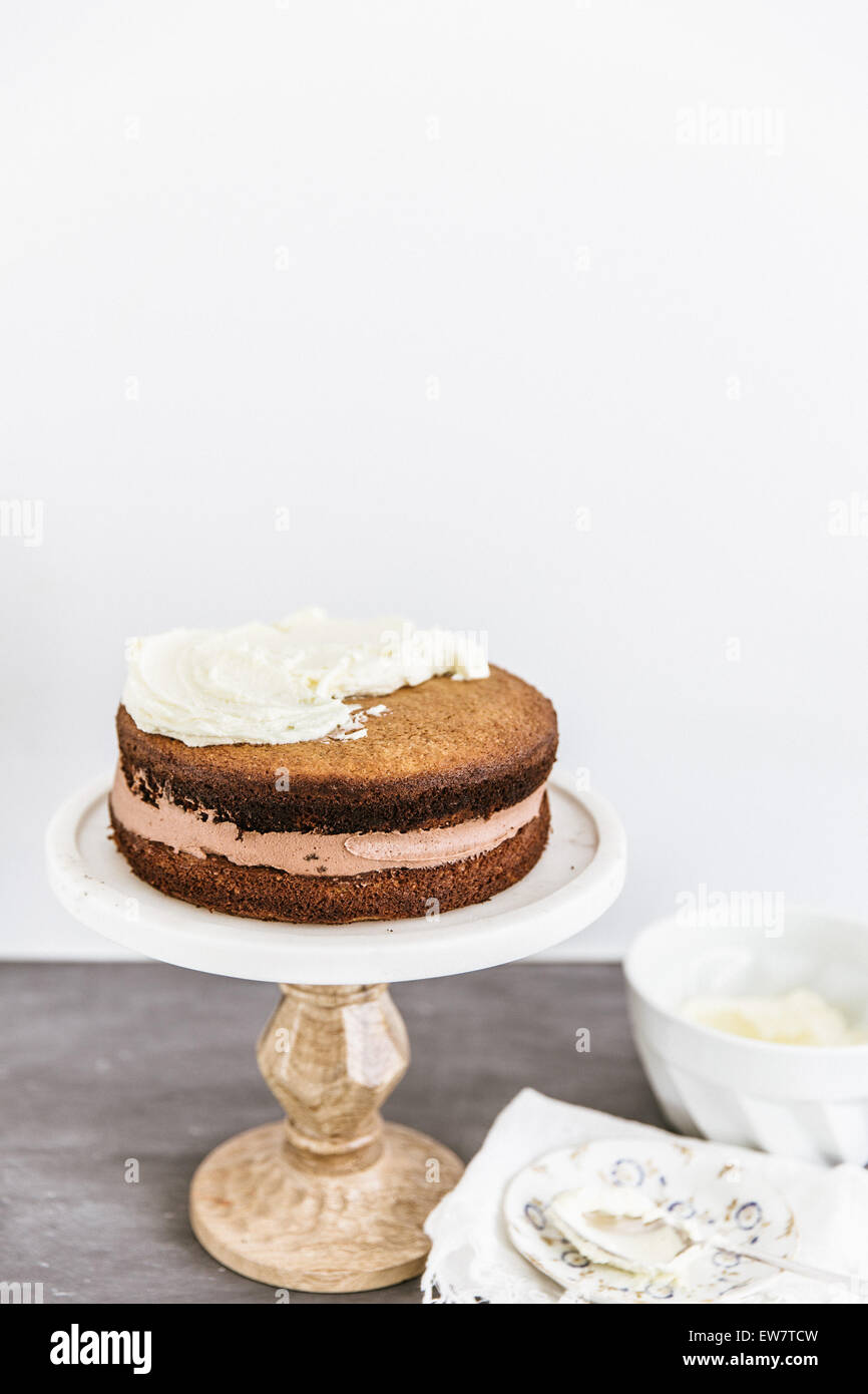 Sponge cake being iced Stock Photo - Alamy