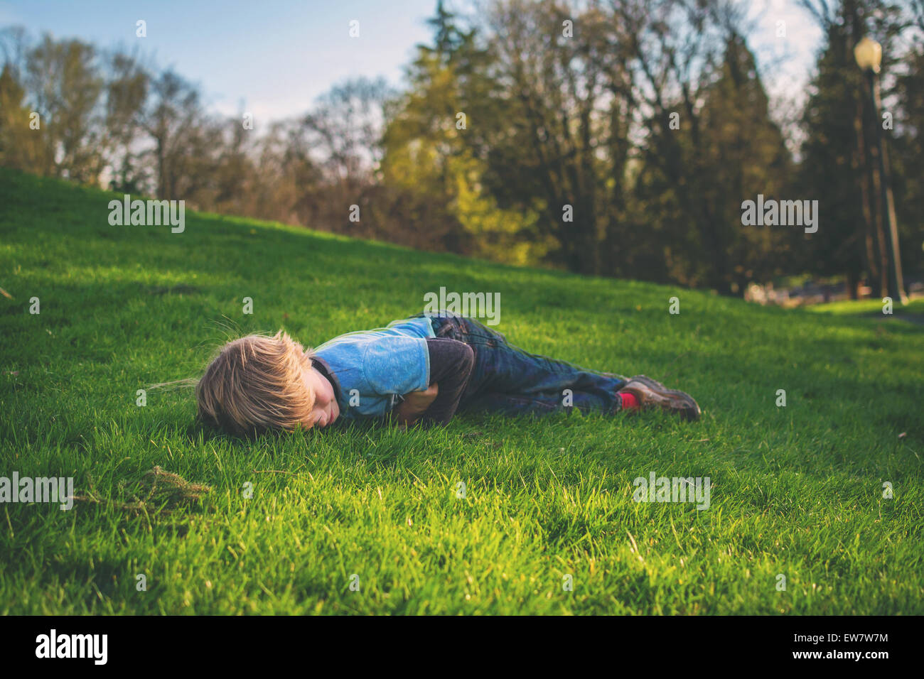 Boy lying down on grass hi-res stock photography and images - Alamy