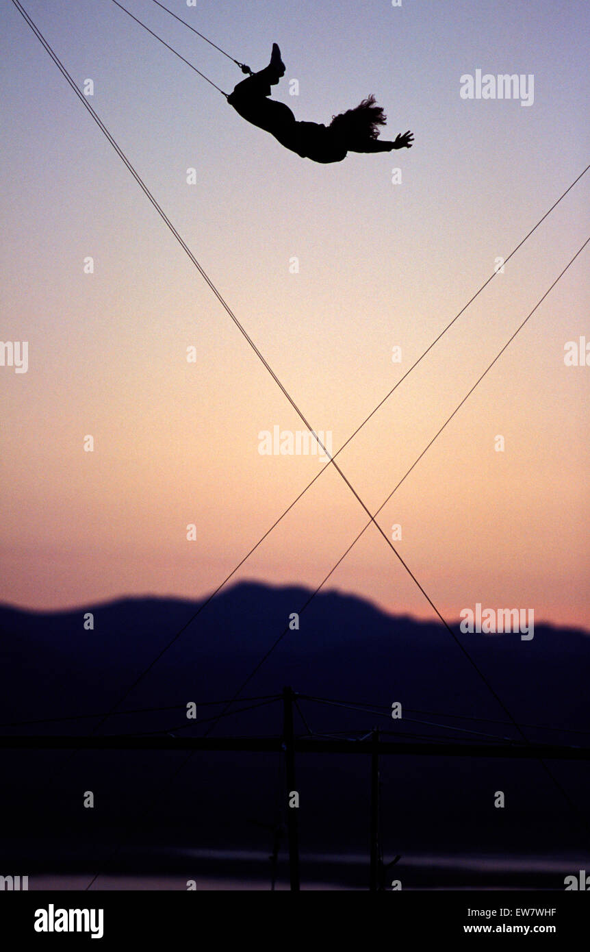 Woman swinging on a trapeze at sunset (silhouette Stock Photo - Alamy