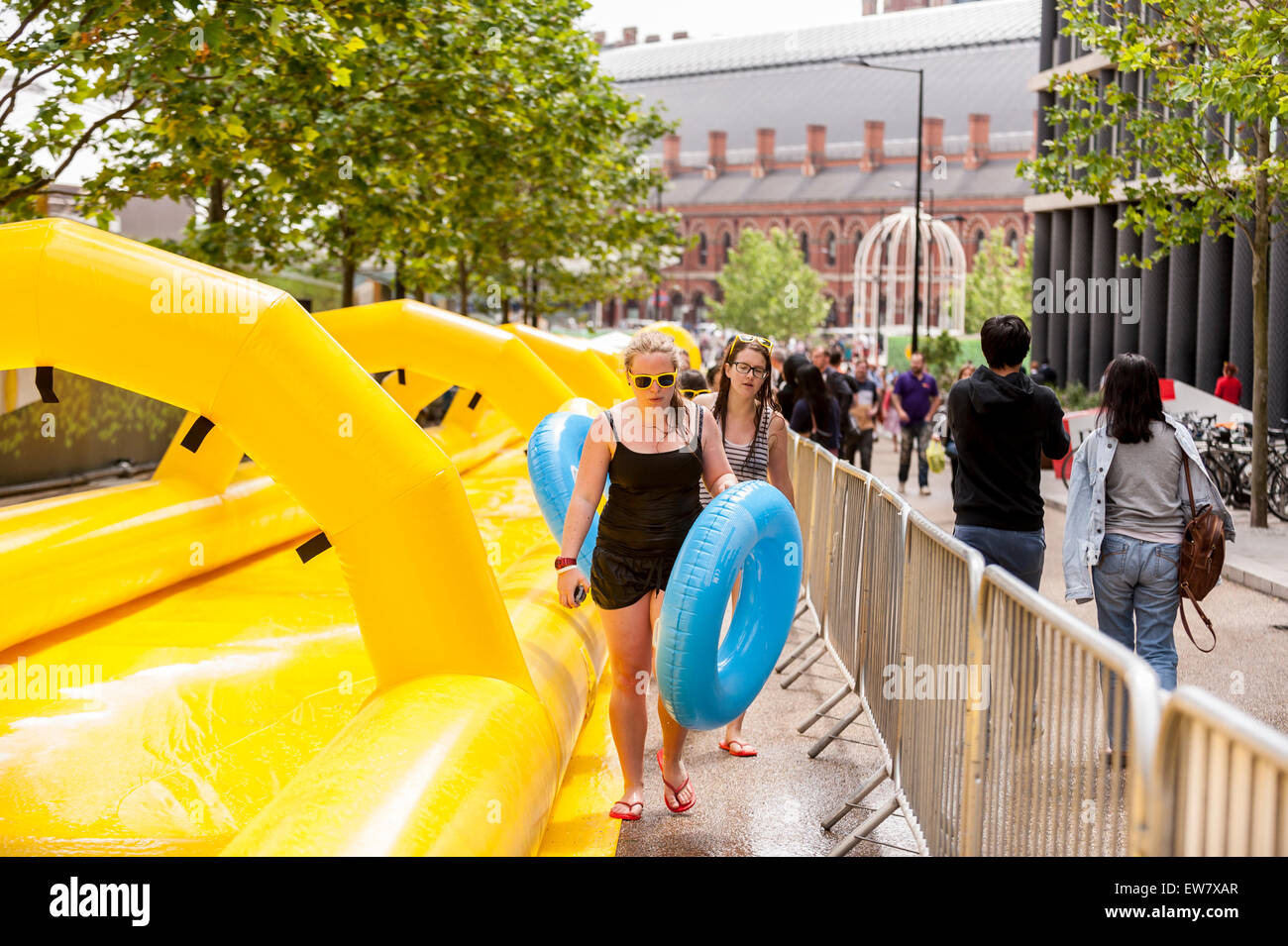 London, UK. 19 June 2015. Onlookers see riders carry their rubber rings ...