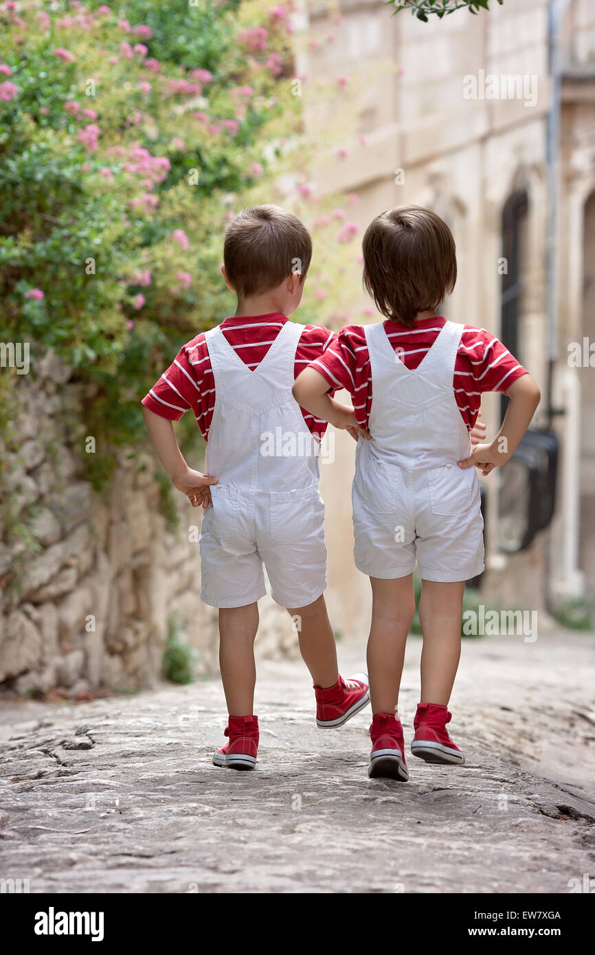 Two adorable kids, walking on the street, back to camera Stock Photo ...