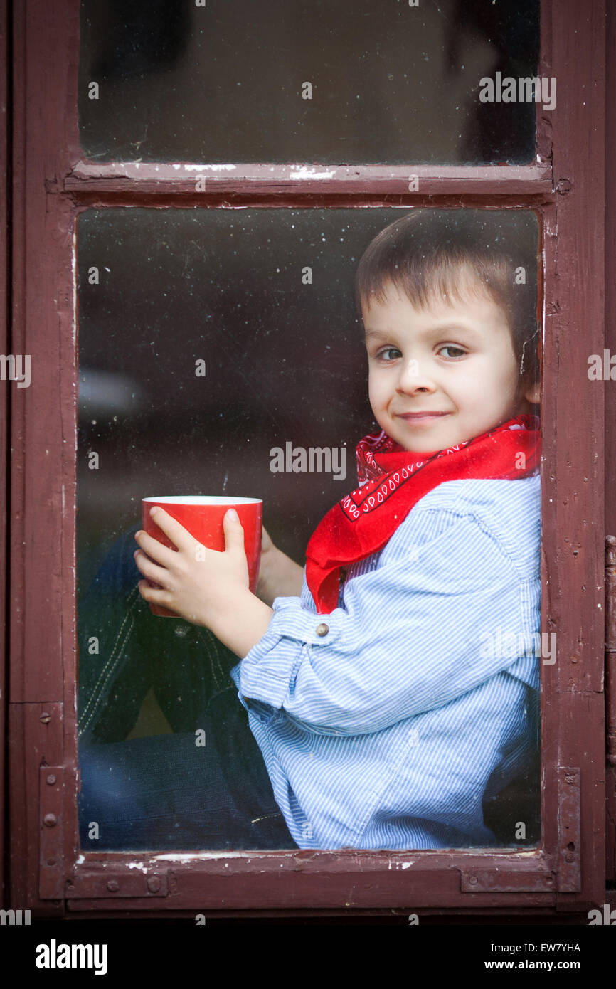 Boy on the window, smiling and drinking tea, having fun Stock Photo - Alamy