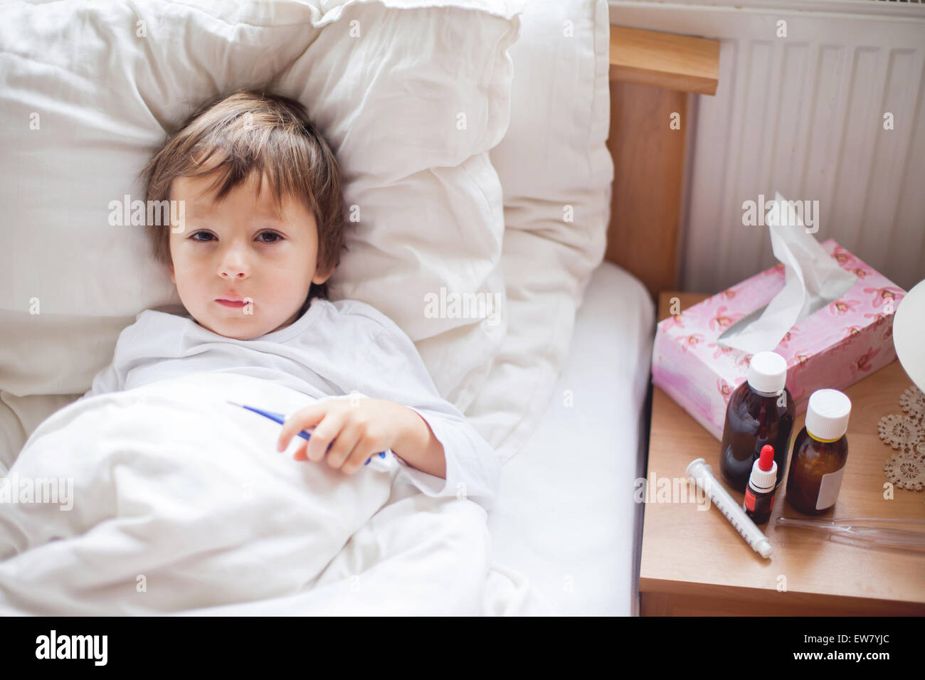 Sick child boy lying in bed with a fever, resting Stock Photo - Alamy