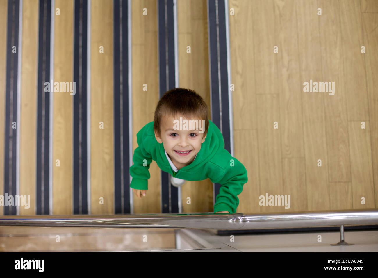 Portrait of a boy from above, standing on a stairs, looking up Stock ...