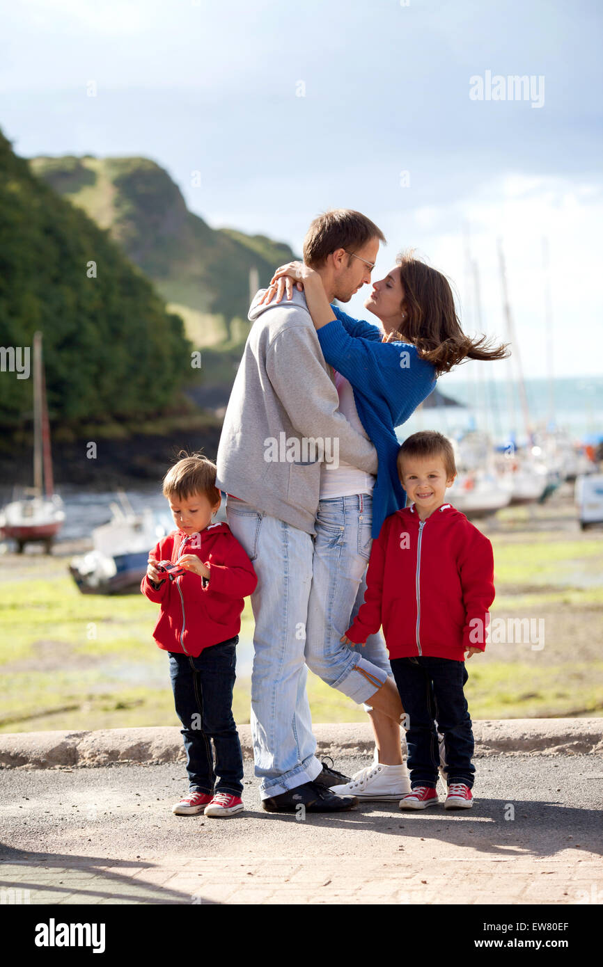 Young family with small kids on a harbor in the afternoon, embracing ...