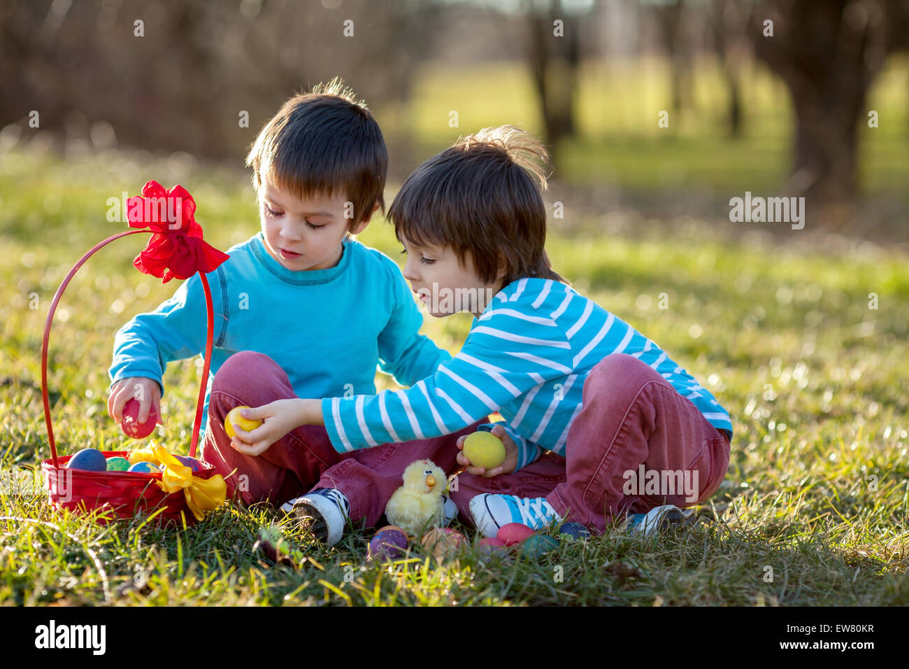 Two boys in the park, having fun with colored eggs for Easter ...
