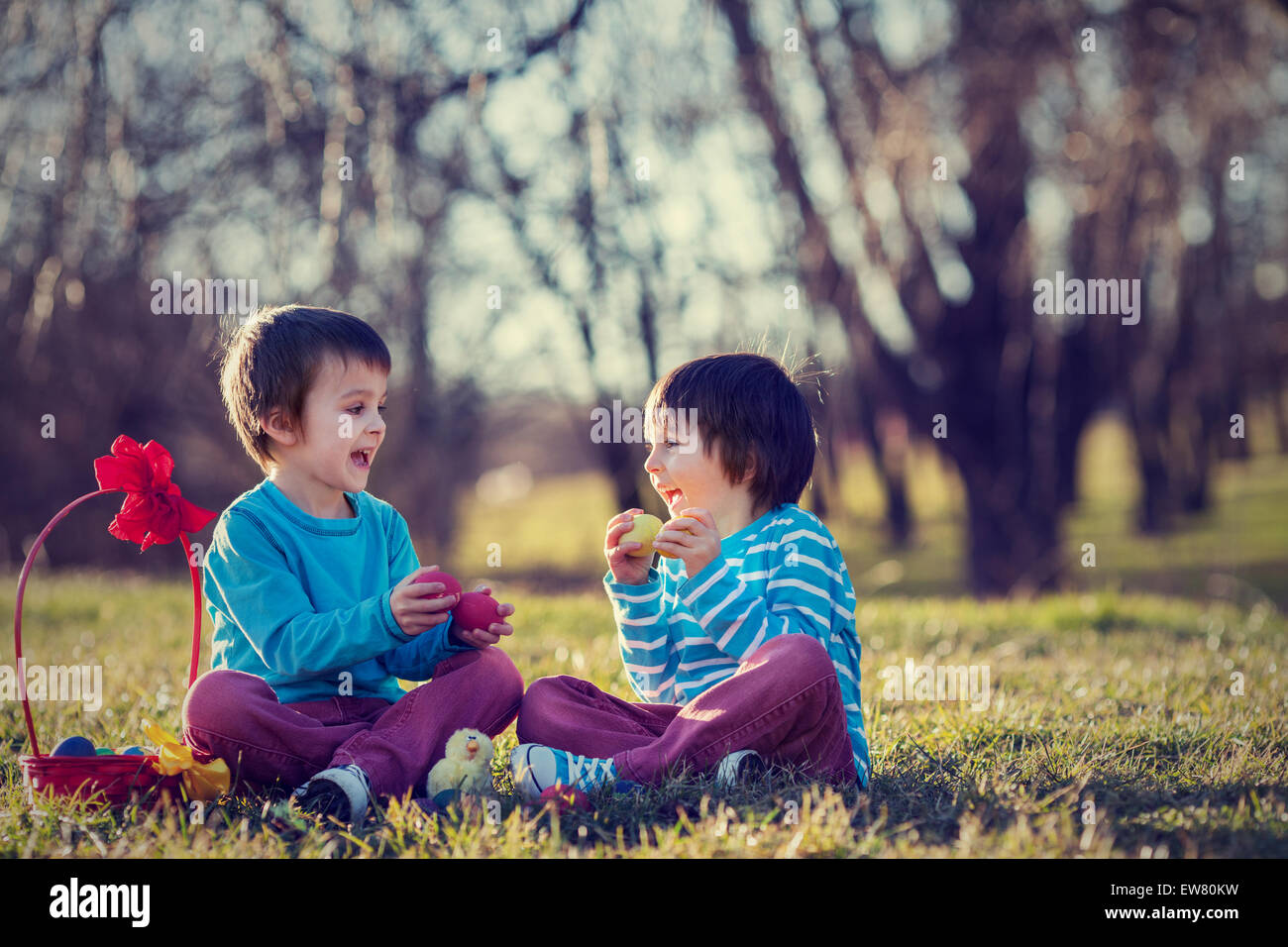 Two boys in the park, having fun with colored eggs for Easter ...