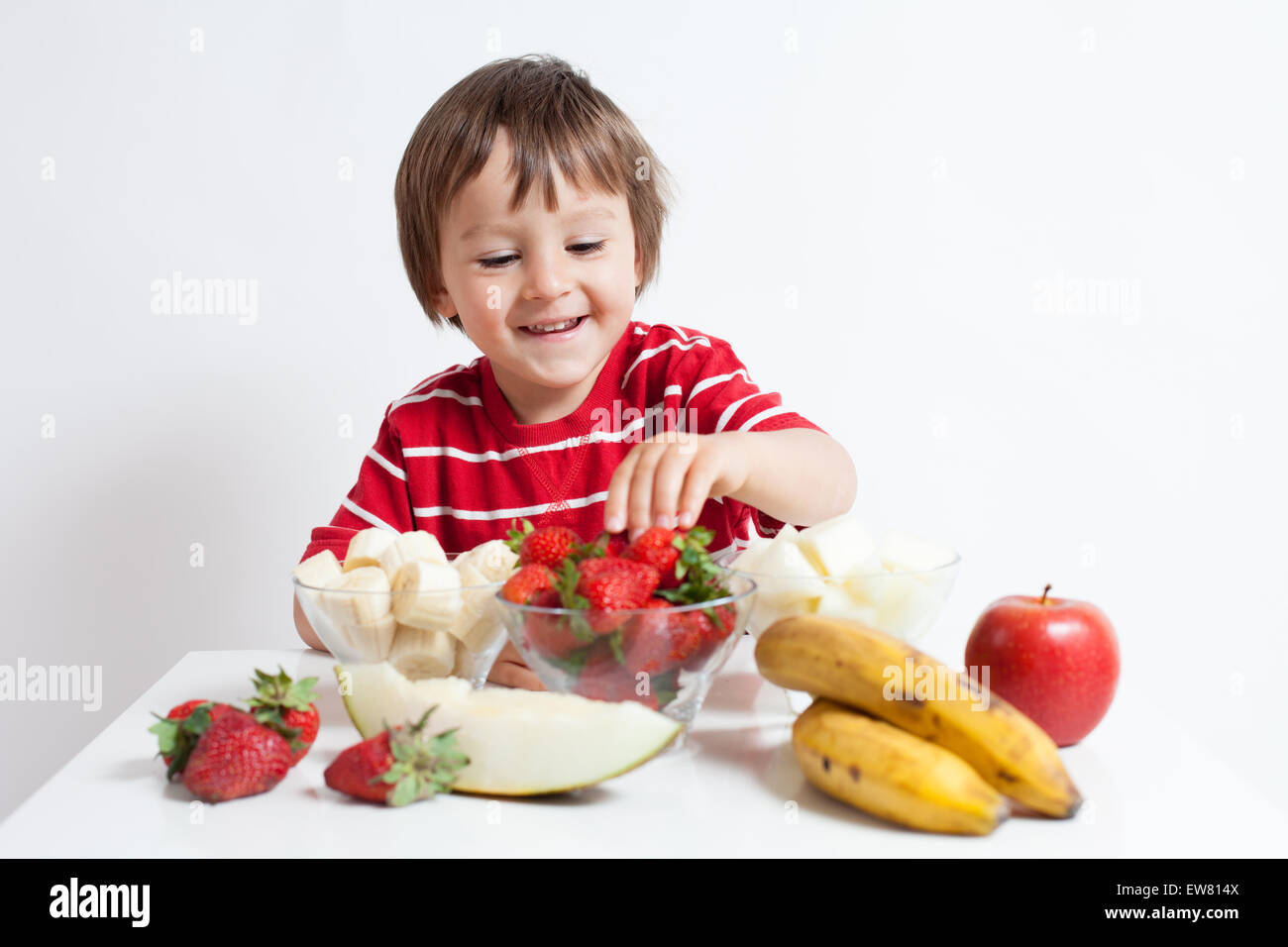 Cute adorable boy, eating fruits Stock Photo - Alamy