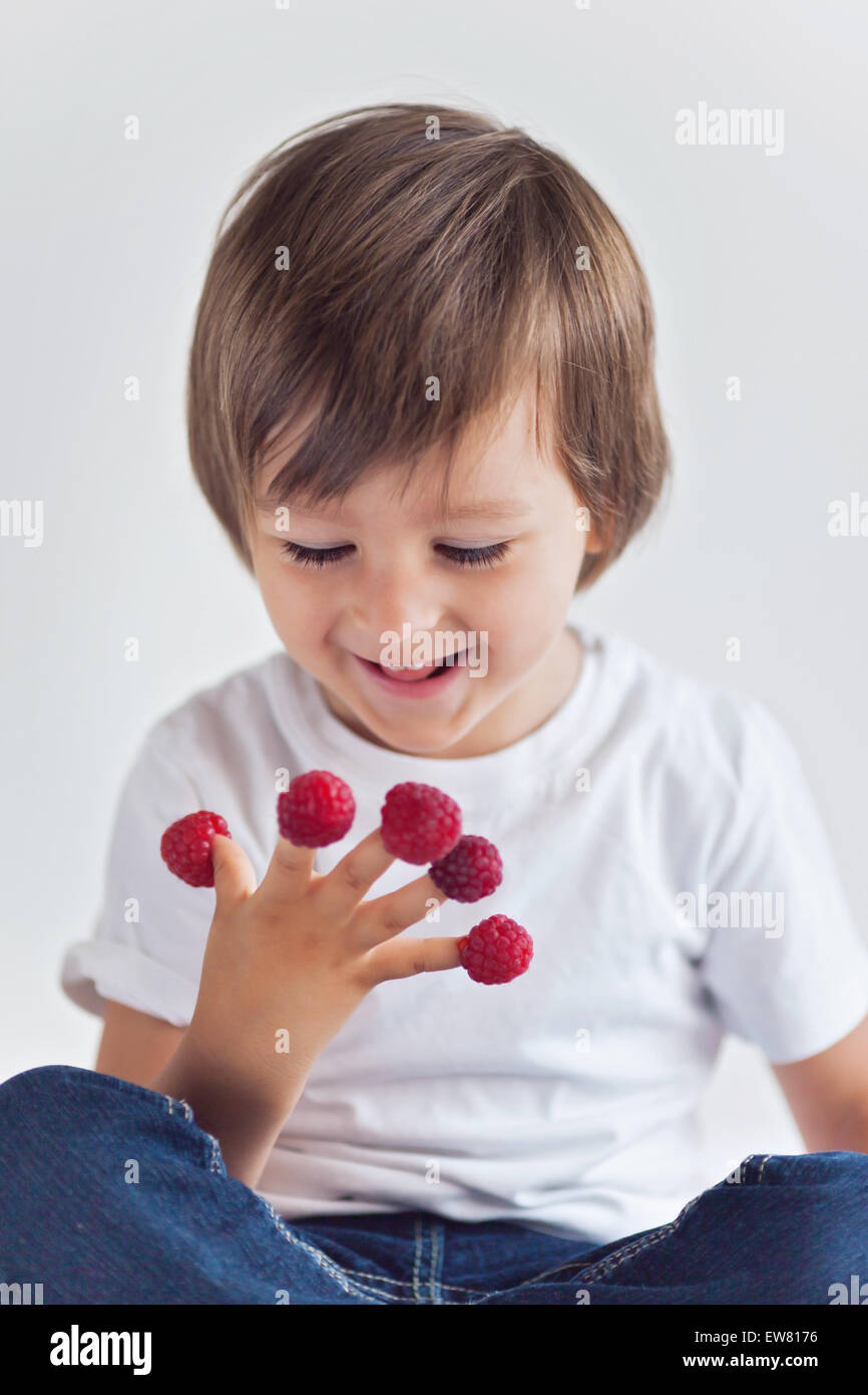 Adorable boy, having fun with raspberries Stock Photo - Alamy