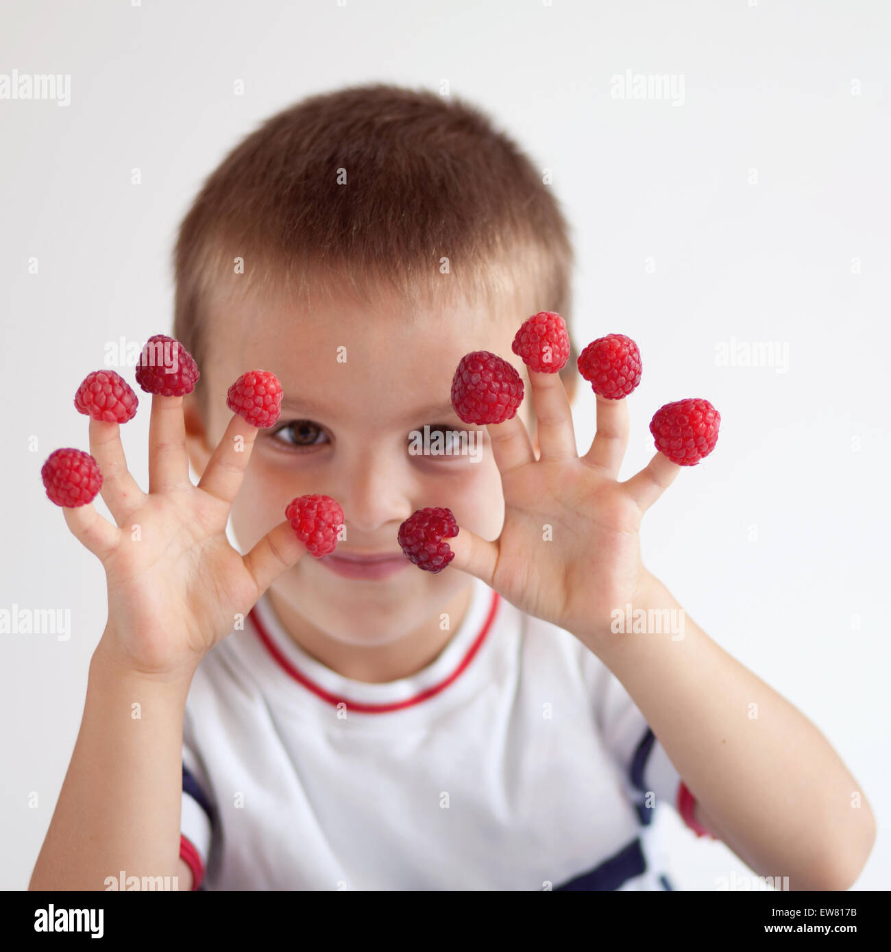 Adorable boy, having fun with raspberries Stock Photo - Alamy