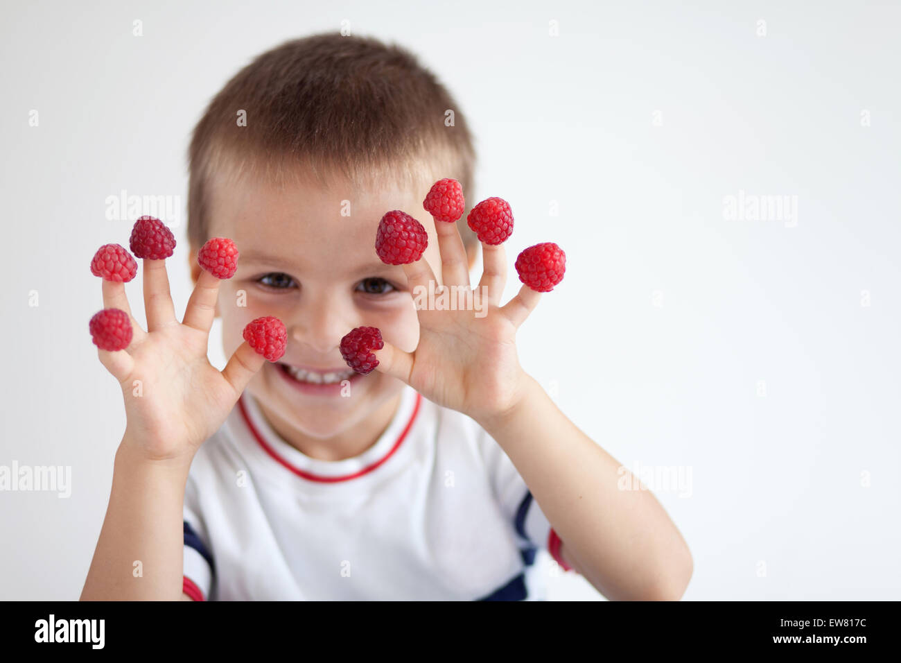 Adorable boy, having fun with raspberries Stock Photo - Alamy
