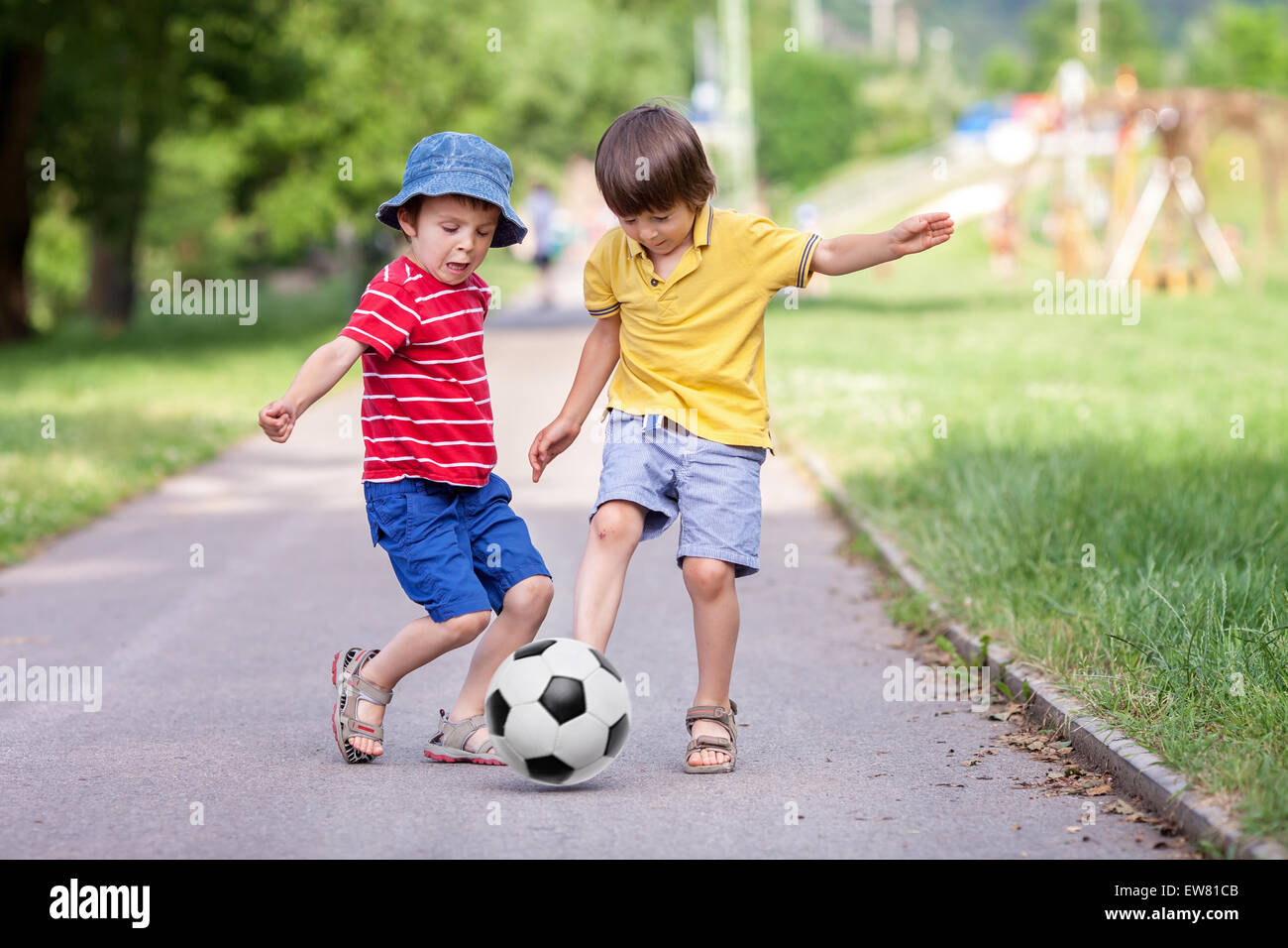 Two cute little kids, playing football together, summertime. Children ...