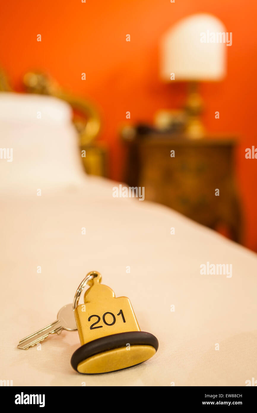 Hotel Room Key lying on Bed with keyring golden Stock Photo - Alamy