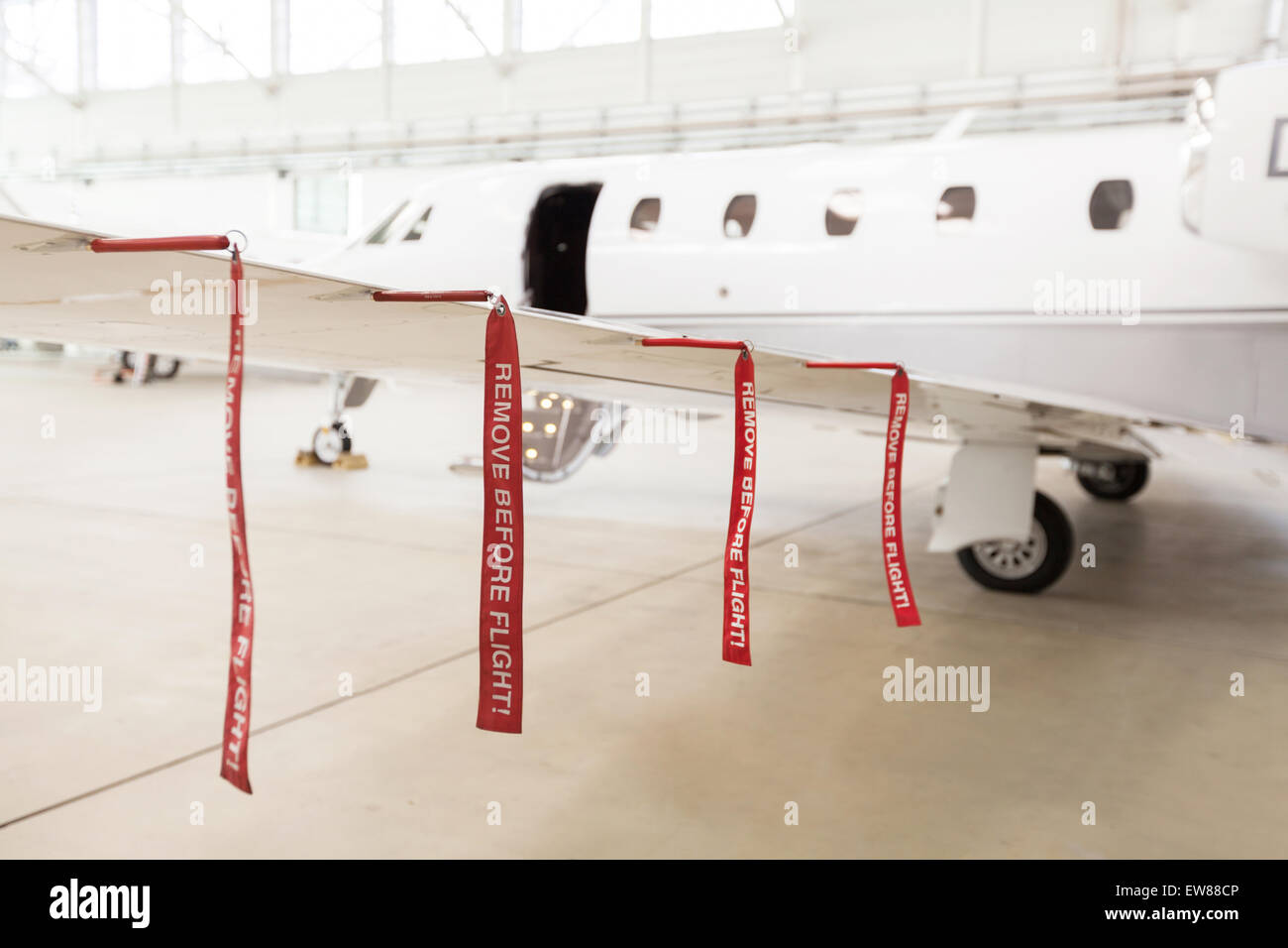 Airplane in Hangar with remove before flight Labels in red warning ...