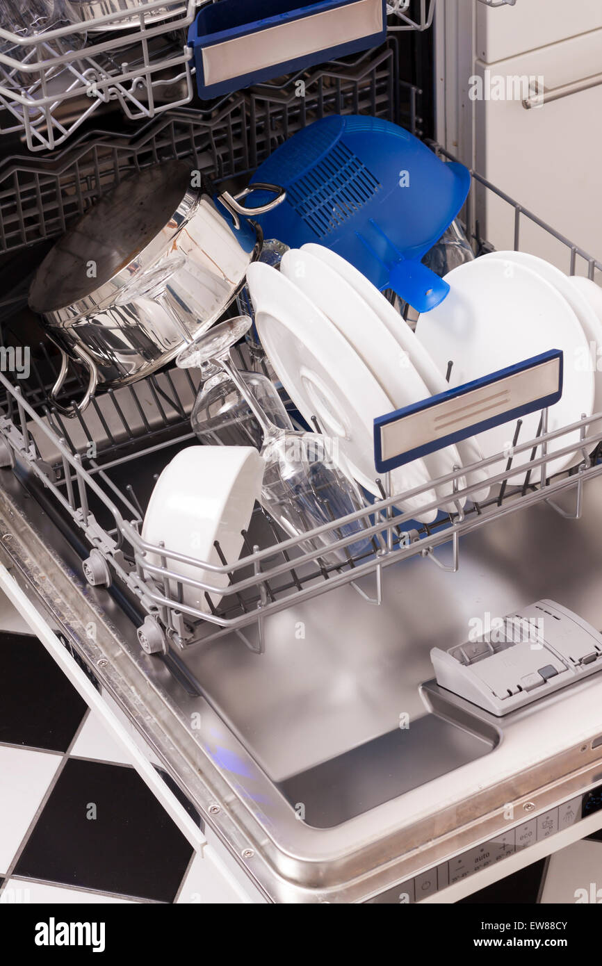 Dishwasher loades in a kitchen with clean dishes and blue light Stock ...