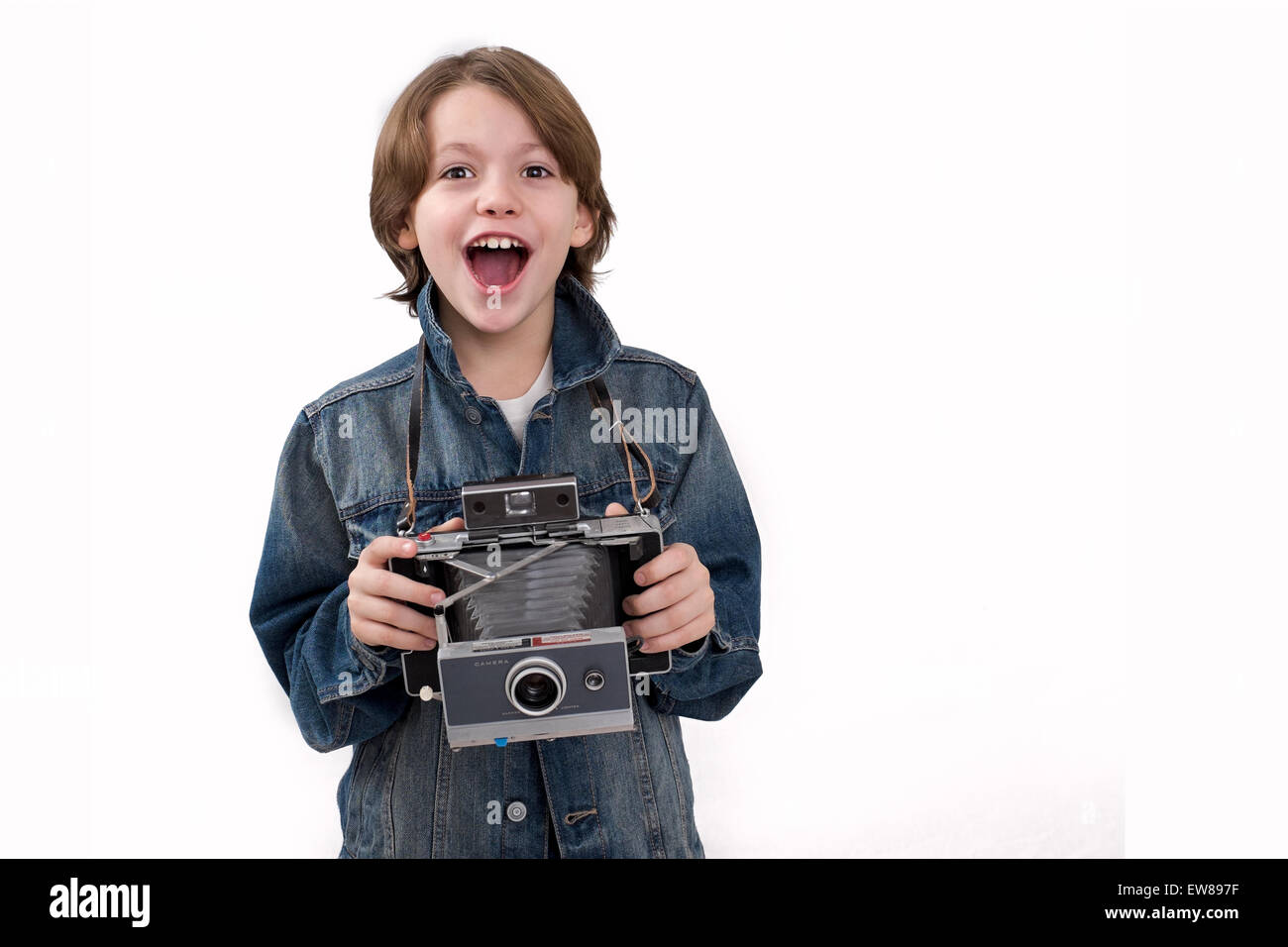 young child photographer holding a instant camera on a white background ...