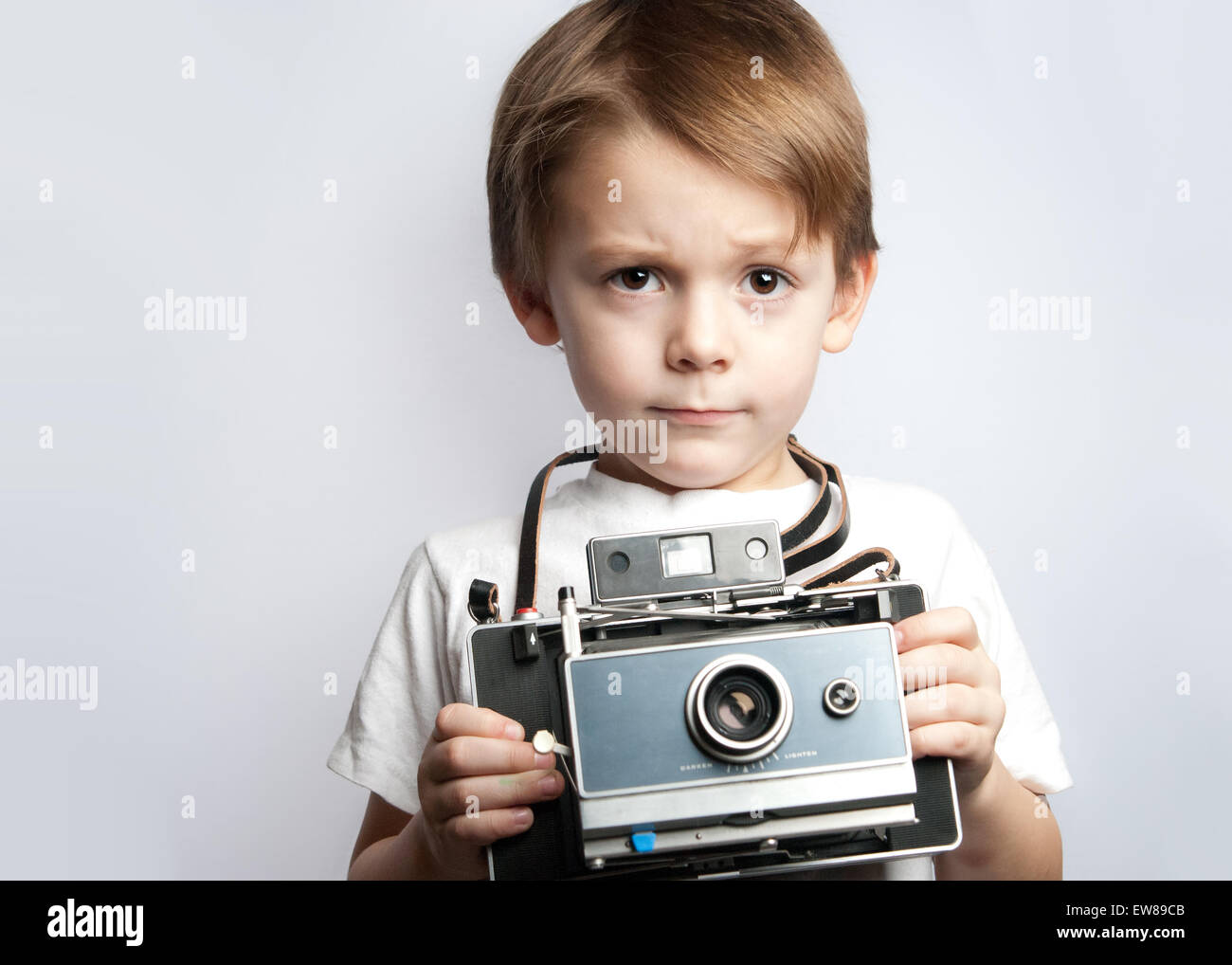 young child holding a instant camera on a white background Stock Photo ...