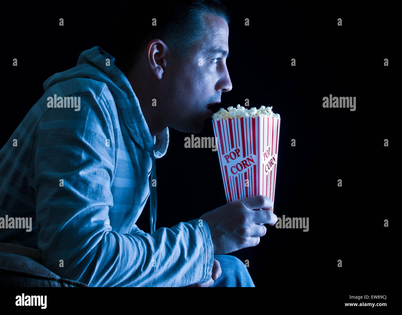 Caucasian man eating popcorn while watch a movie on television Stock ...