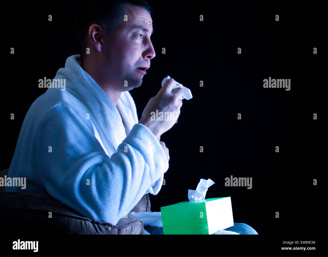crying Caucasian man with a tissue watching a movie on television Stock ...