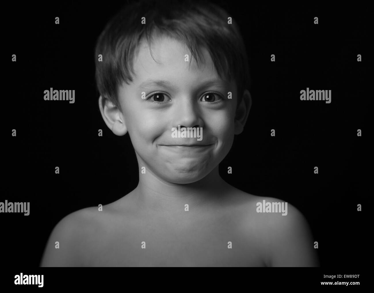 young happy smileing young boy possses on a black background Stock ...