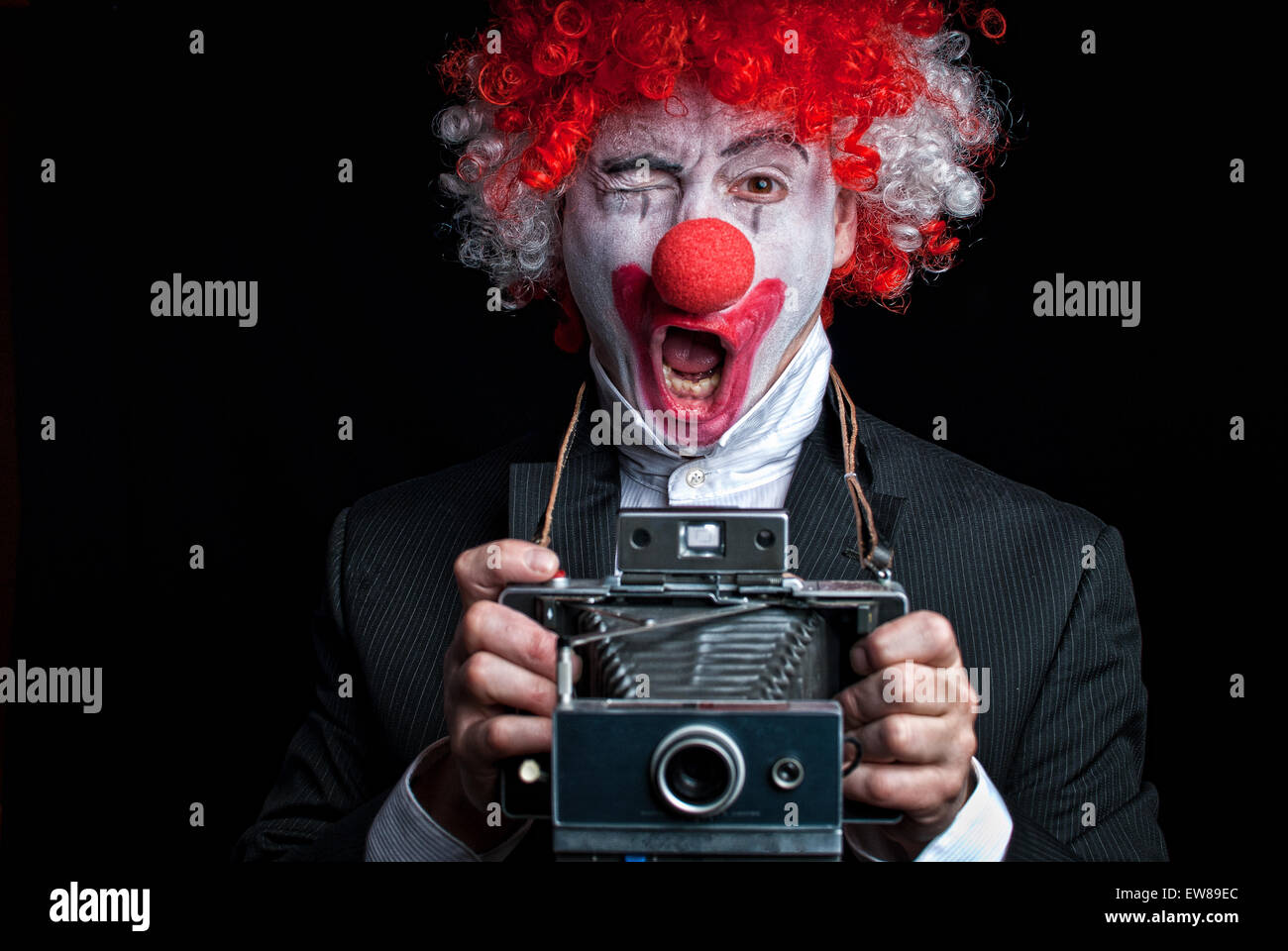 colorful clown with an instant camera on a black background Stock Photo ...