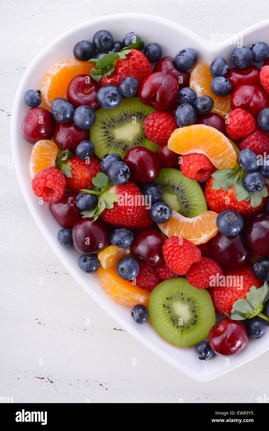 Colorful rainbow fruit including raspberries, strawberries, cherries ...