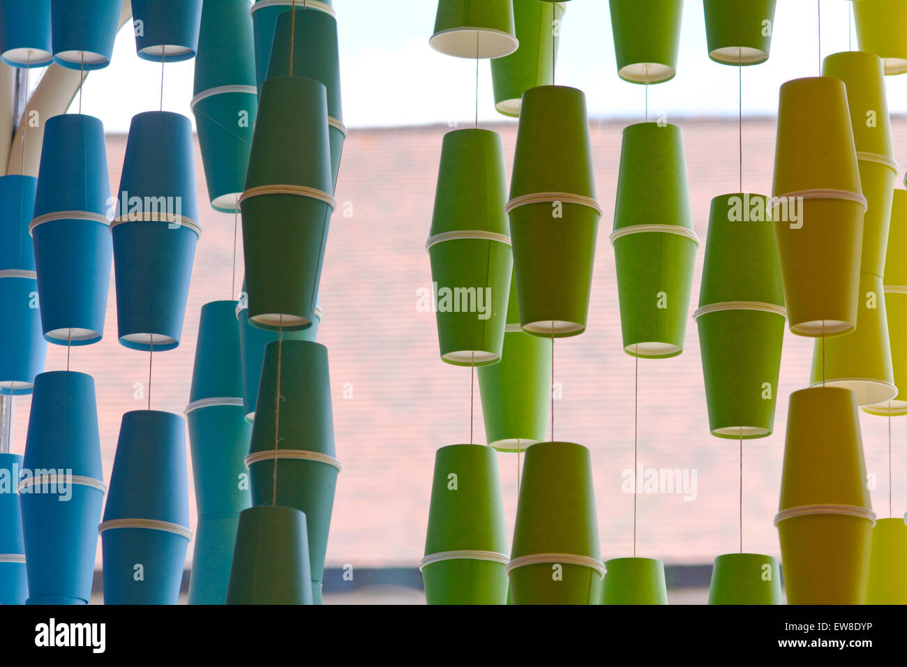 Color paper cups hanging in window display in shop Stock Photo - Alamy