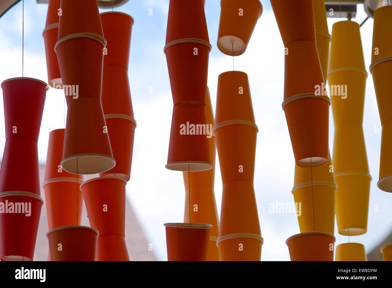 Color paper cups hanging in window display in shop Stock Photo - Alamy