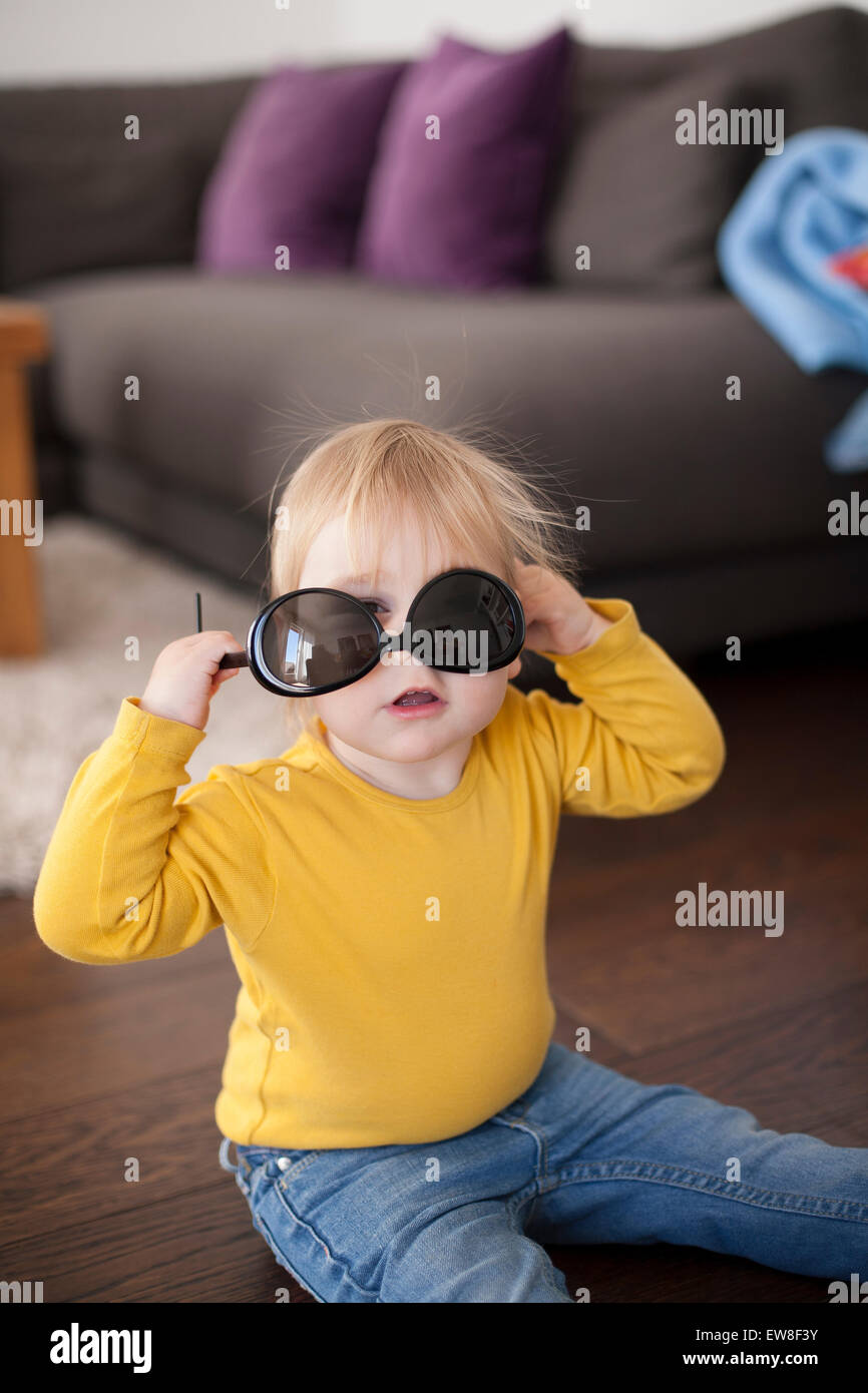 two years aged blonde happy baby yellow shirt and blue jeans playing ...