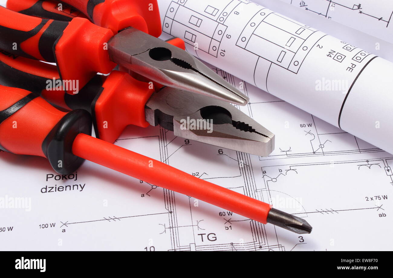 Rolls of electrical diagrams with work tools lying on construction ...