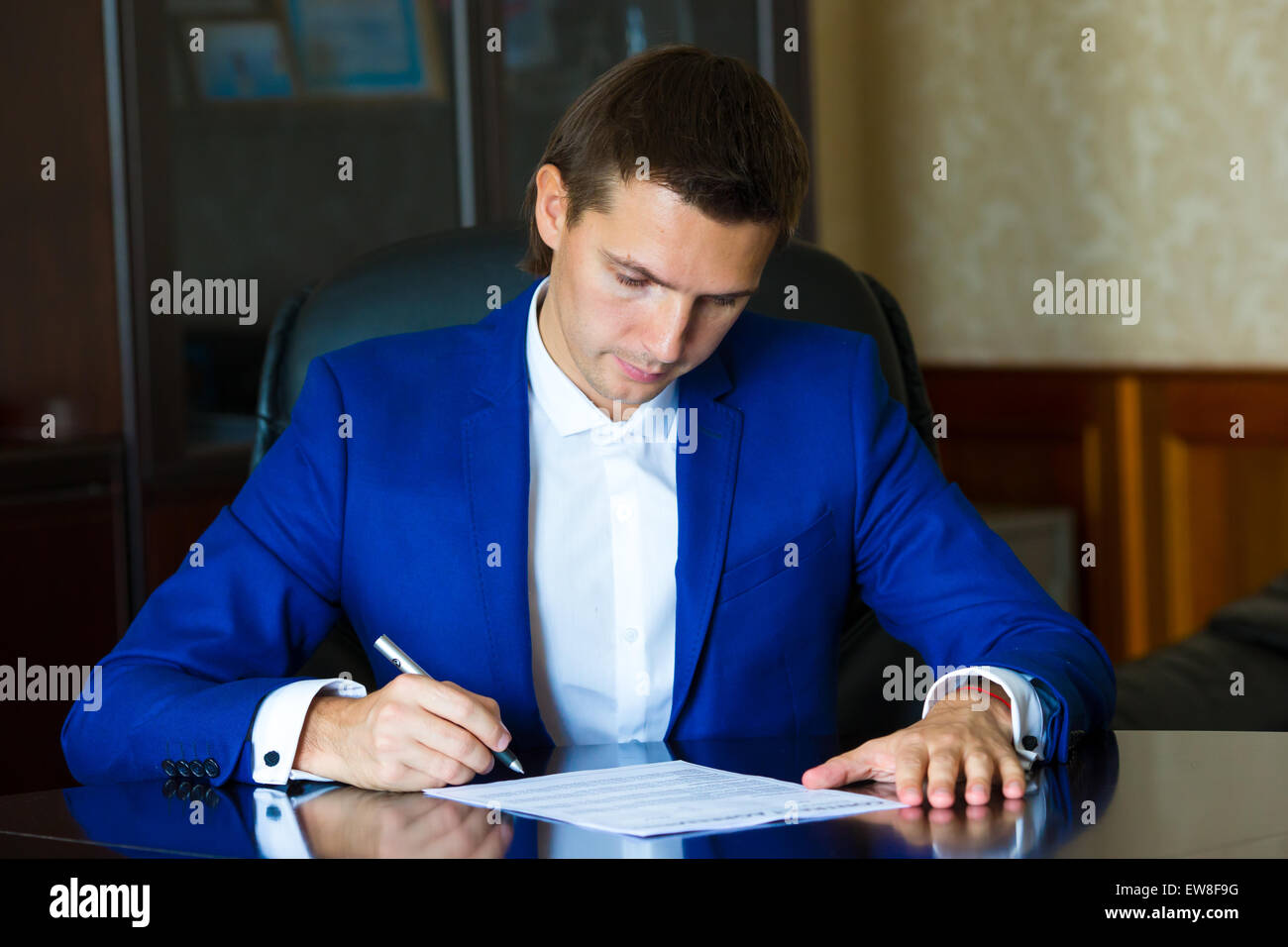 Business man signing a contract in big office Stock Photo - Alamy