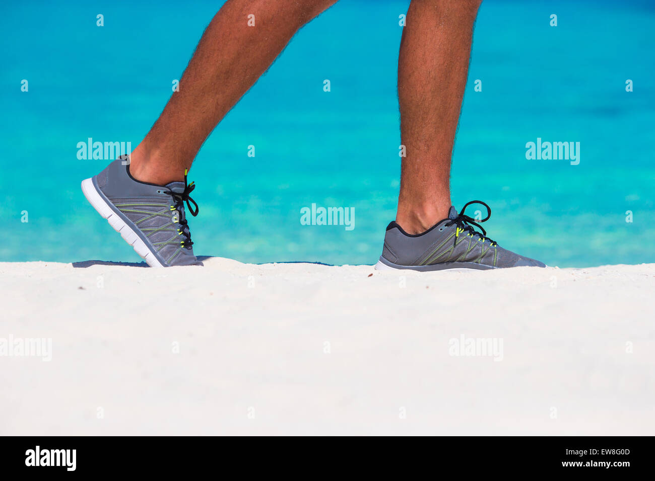 Young male runner getting ready to start on white beach Stock Photo - Alamy