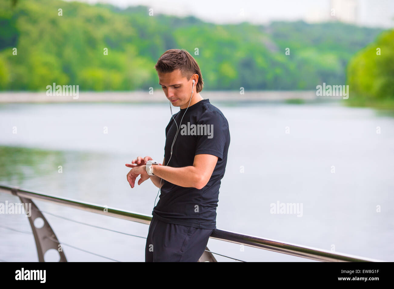 Runner looking at smart watch heart rate monitor having break while ...