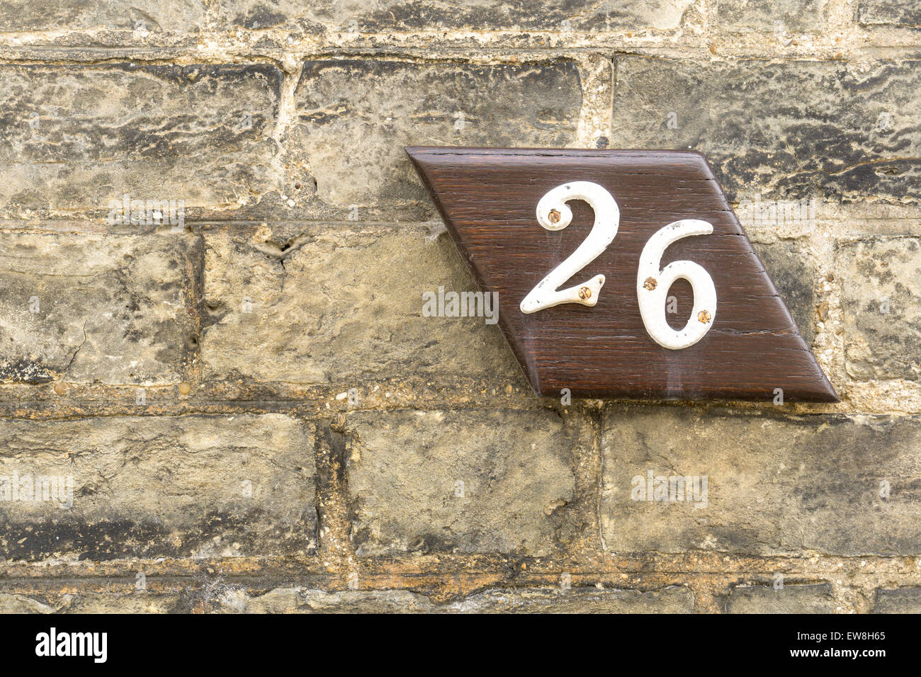 House number 26 twenty six on a brick wall conceptual image closeup ...