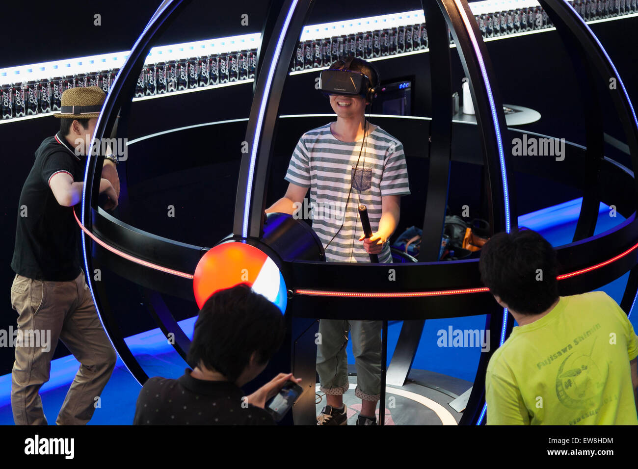 People look at a man playing with a virtual reality head-mounter ...