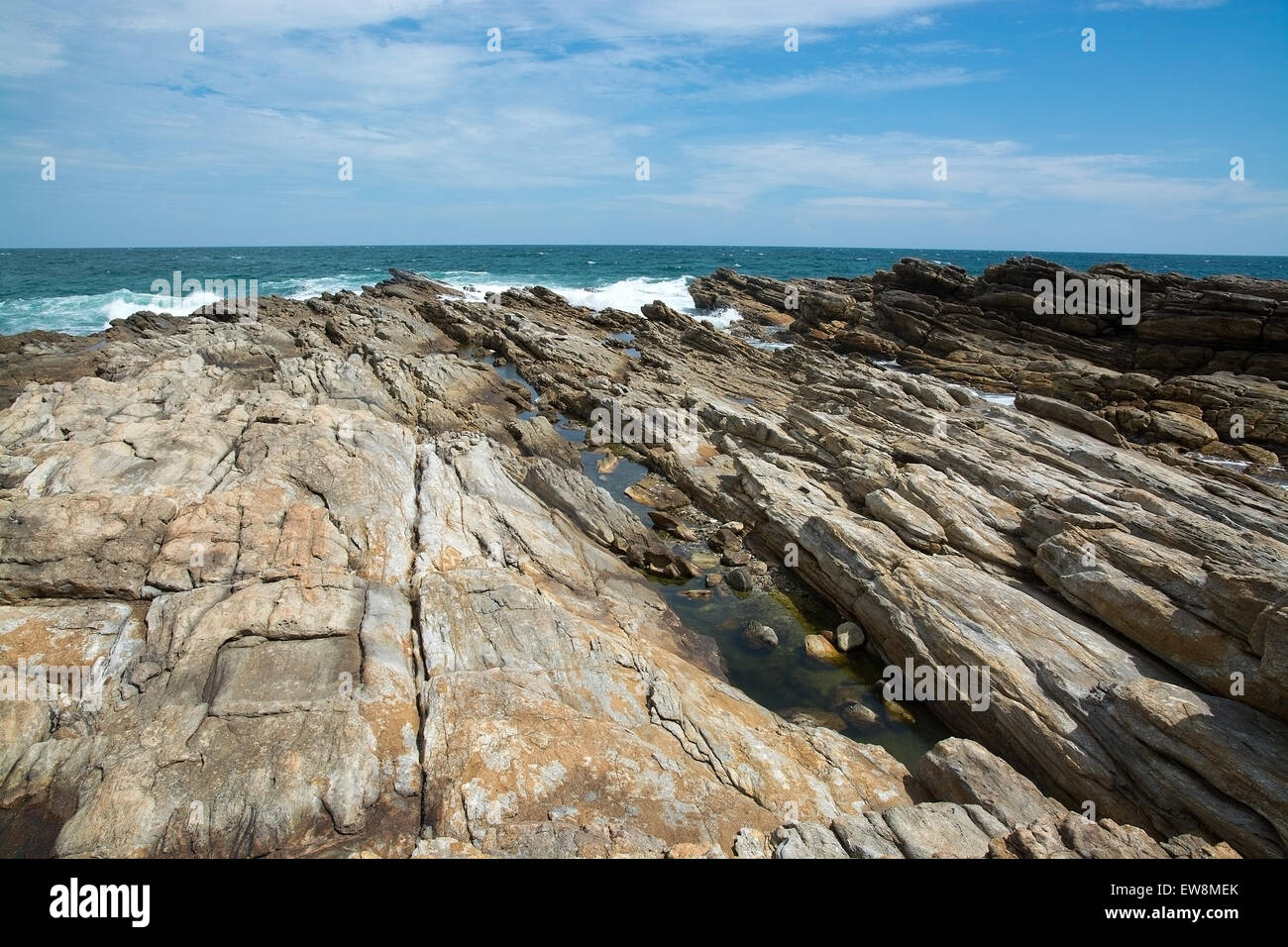 Rocky coast landscape with metamorphic rocks and splashing foaming ...