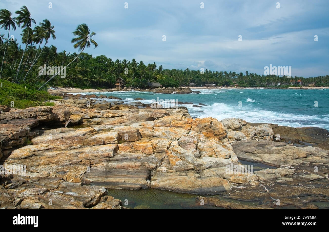 Rocky coast landscape with metamorphic rocks and splashing foaming ...