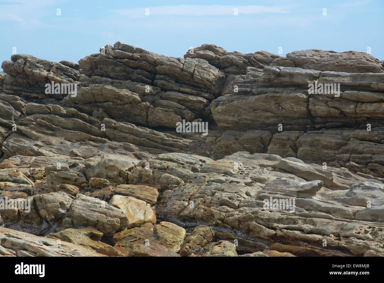 Rocky coast landscape with metamorphic rocks and splashing foaming ...