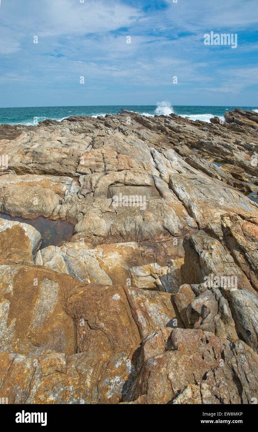 Rocky coast landscape with metamorphic rocks and splashing foaming ...