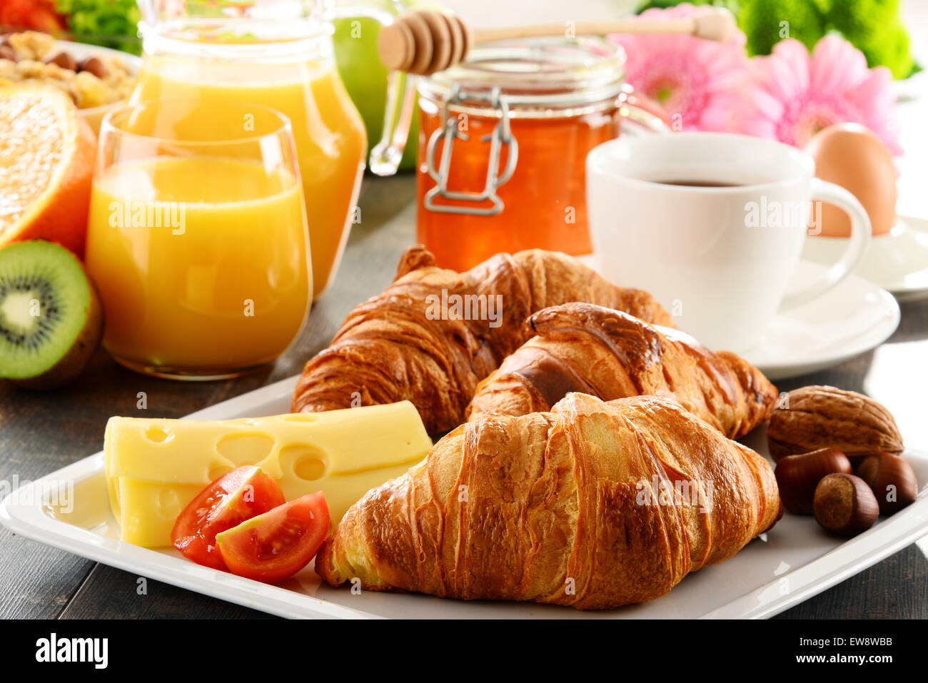 Breakfast consisting of fruits, orange juice, coffee, honey, bread and ...